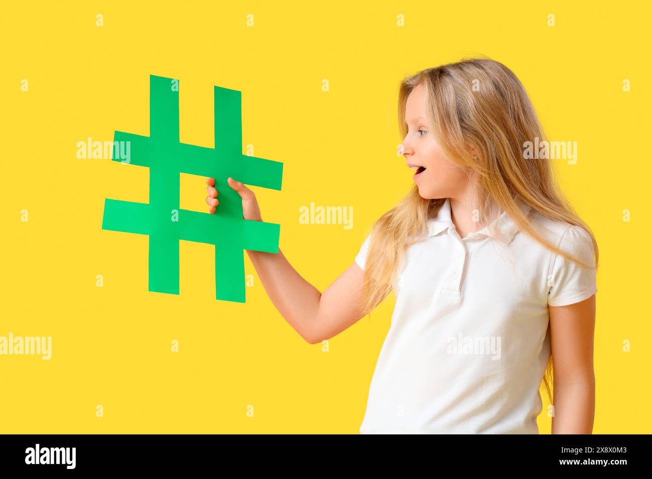 Cute teenage girl with hashtag on yellow background Stock Photo - Alamy