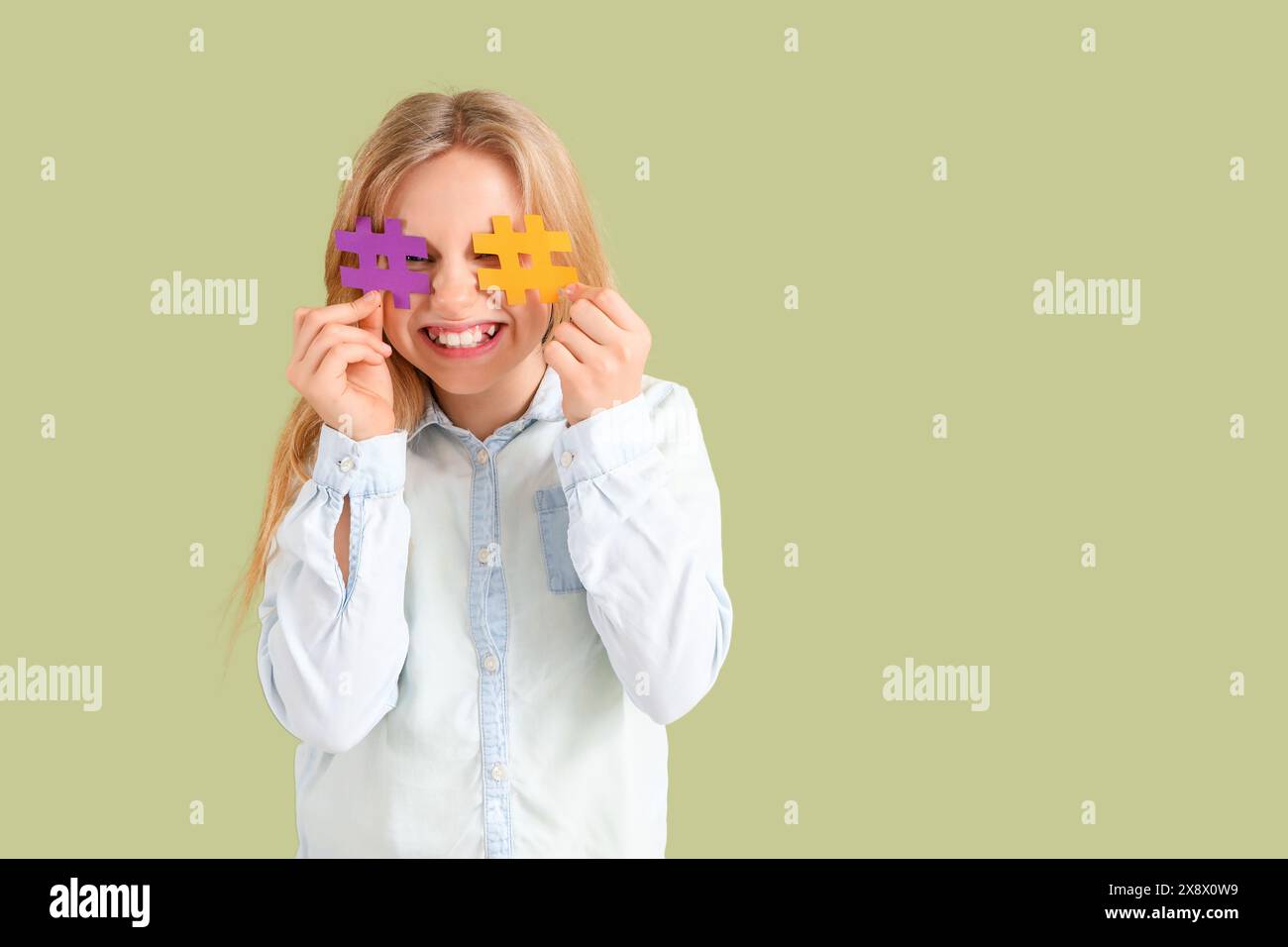 Cute teenage girl with hashtags on green background Stock Photo - Alamy