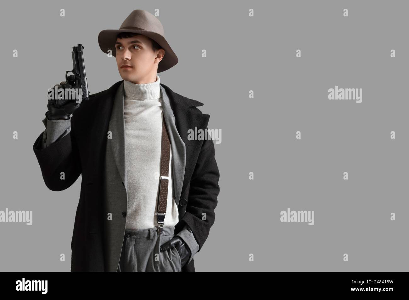 Male spy with gun on grey background Stock Photo - Alamy