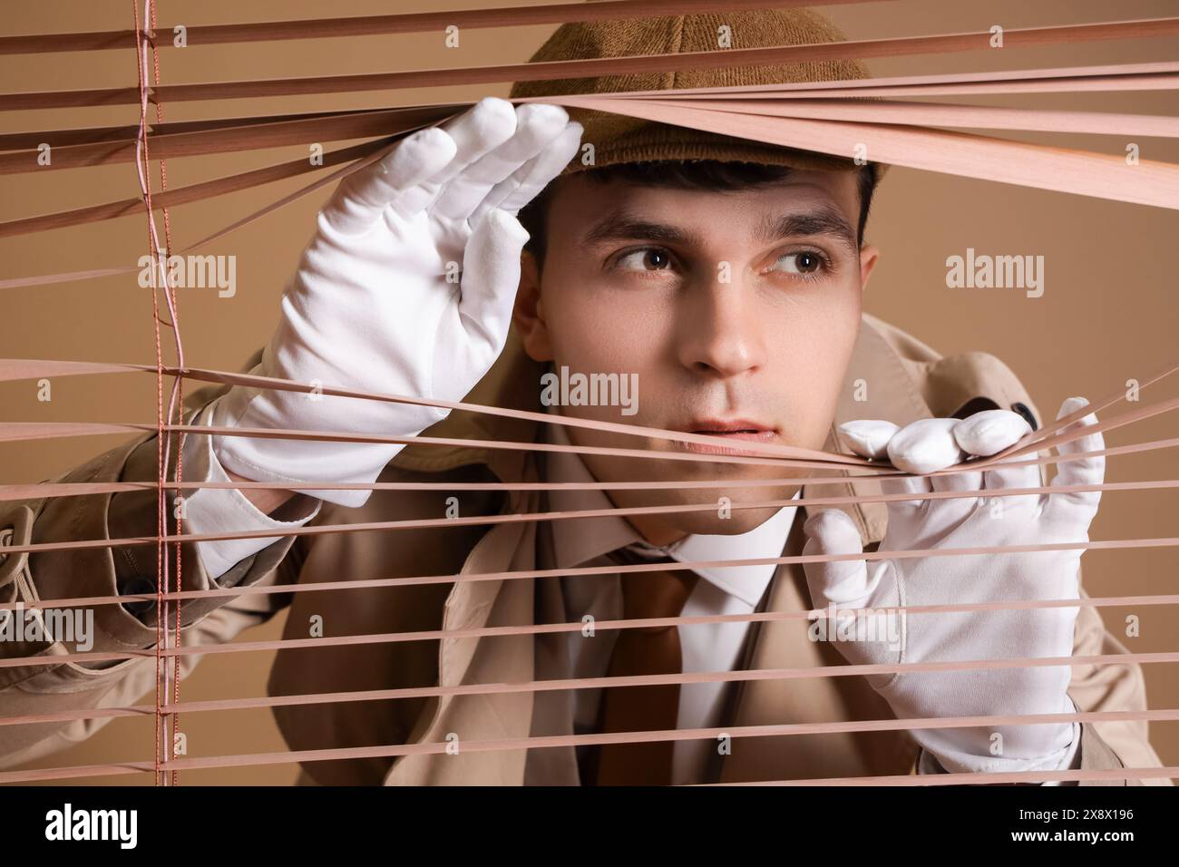 Male spy looking through blinds on brown background, closeup Stock ...