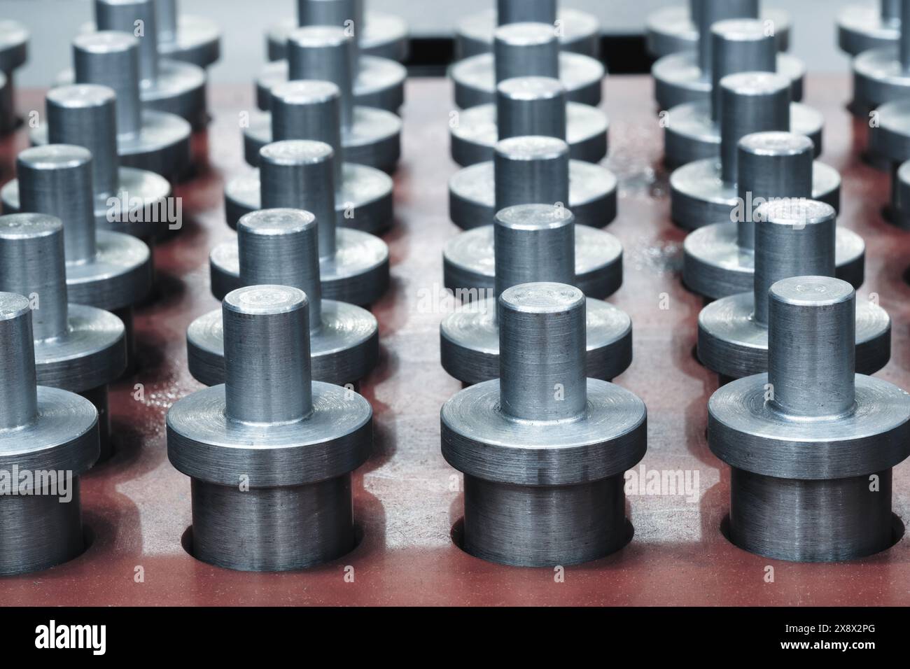 A row of metal cylinders with a hole in the middle. The cylinders are ...
