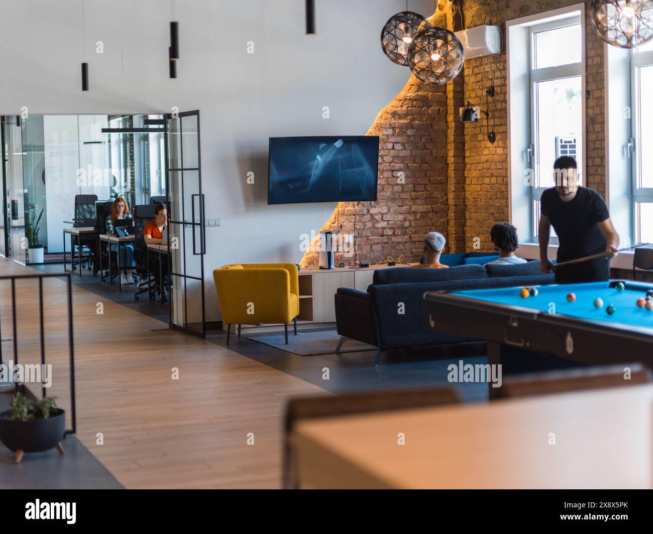 In a setting of modern, glass-walled business startup offices, the open ...