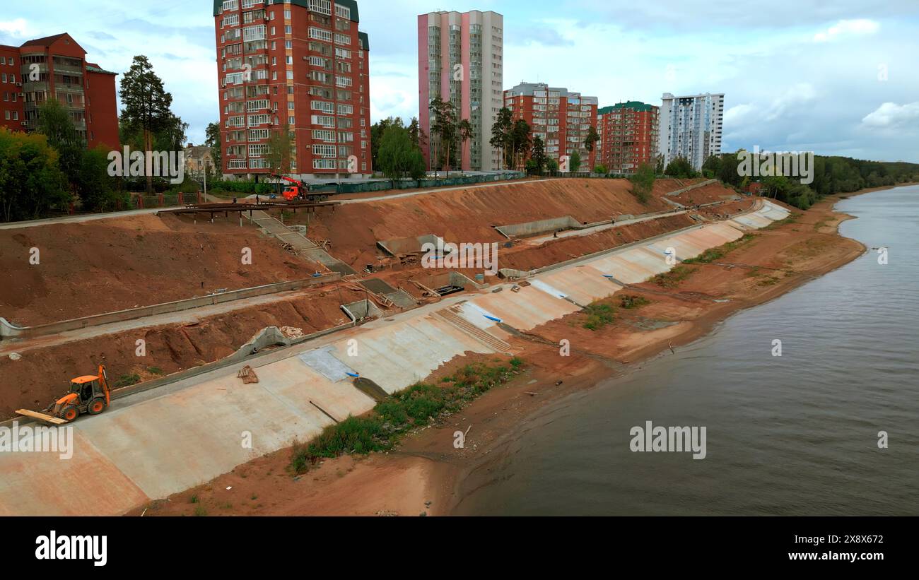 Aerial view of construction site on city embankment next to the river ...