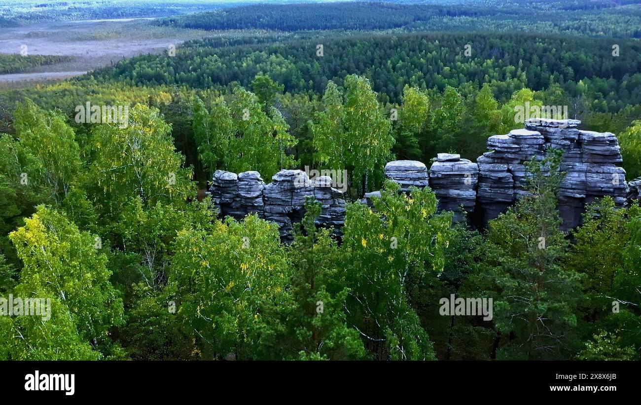 Aerial view of rock cliffs among green summer trees. Footage. Tops of ...