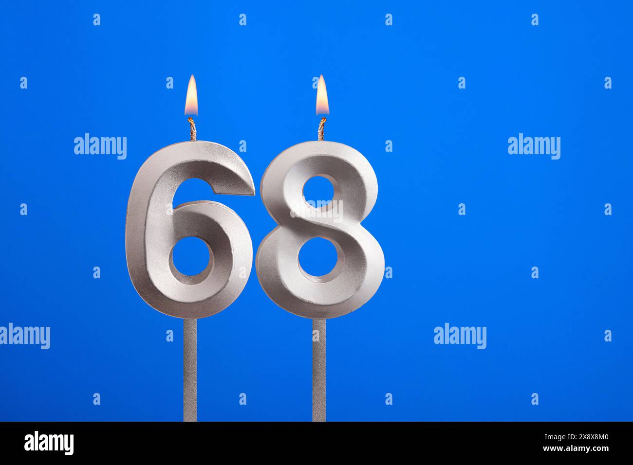 Birthday number 68 - Candle lit on blue background Stock Photo - Alamy