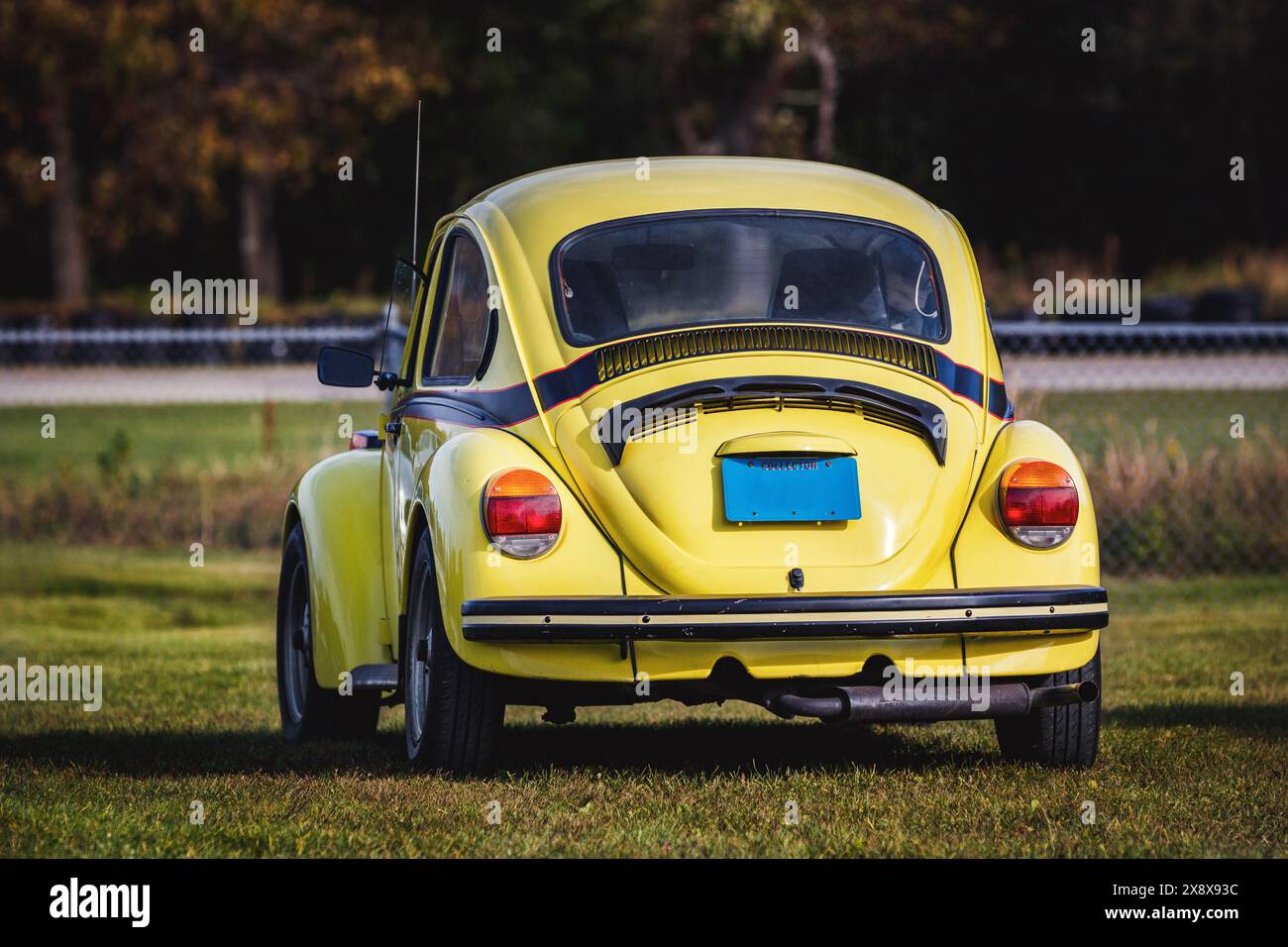 Small yellow German car sitting in a grassy field at a race track Stock ...