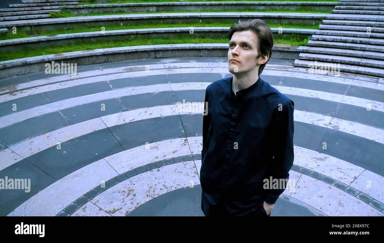 Tall man in black clothes standing in the meddle of amphitheater. Stock ...