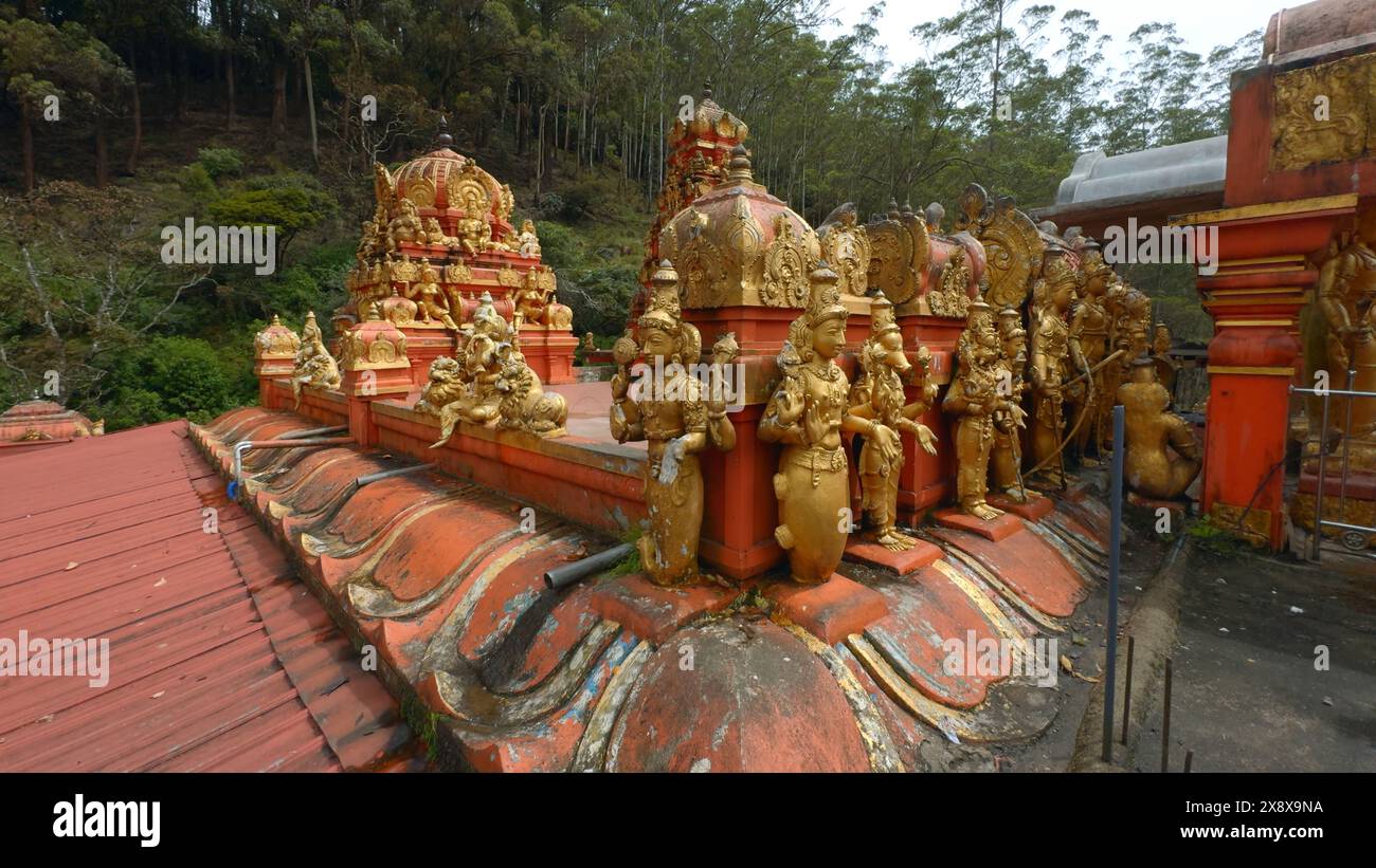 Hindu temple with golden statues. Action. Red temple with golden ...