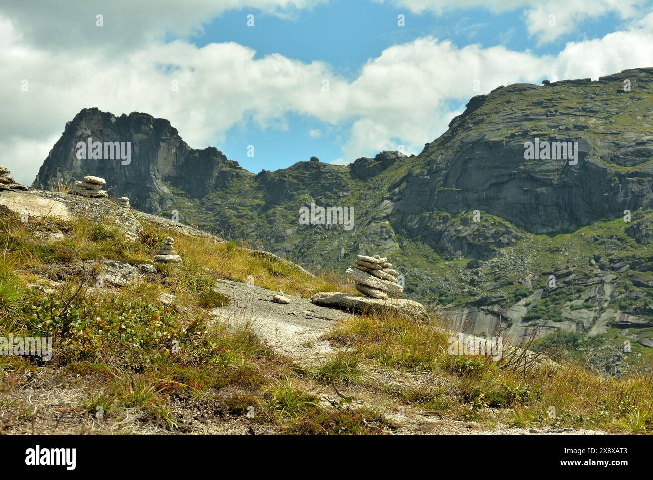 Small stone pyramids on the edge of a high cliff overlooking mountain ...