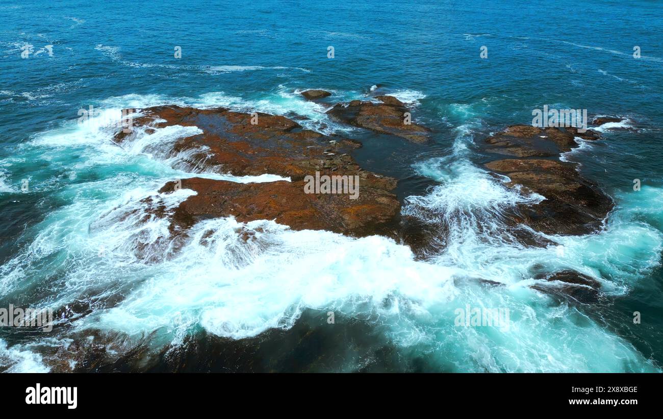 Aerial view of ocean waves crashing into rocks. Clip. Flying above ...