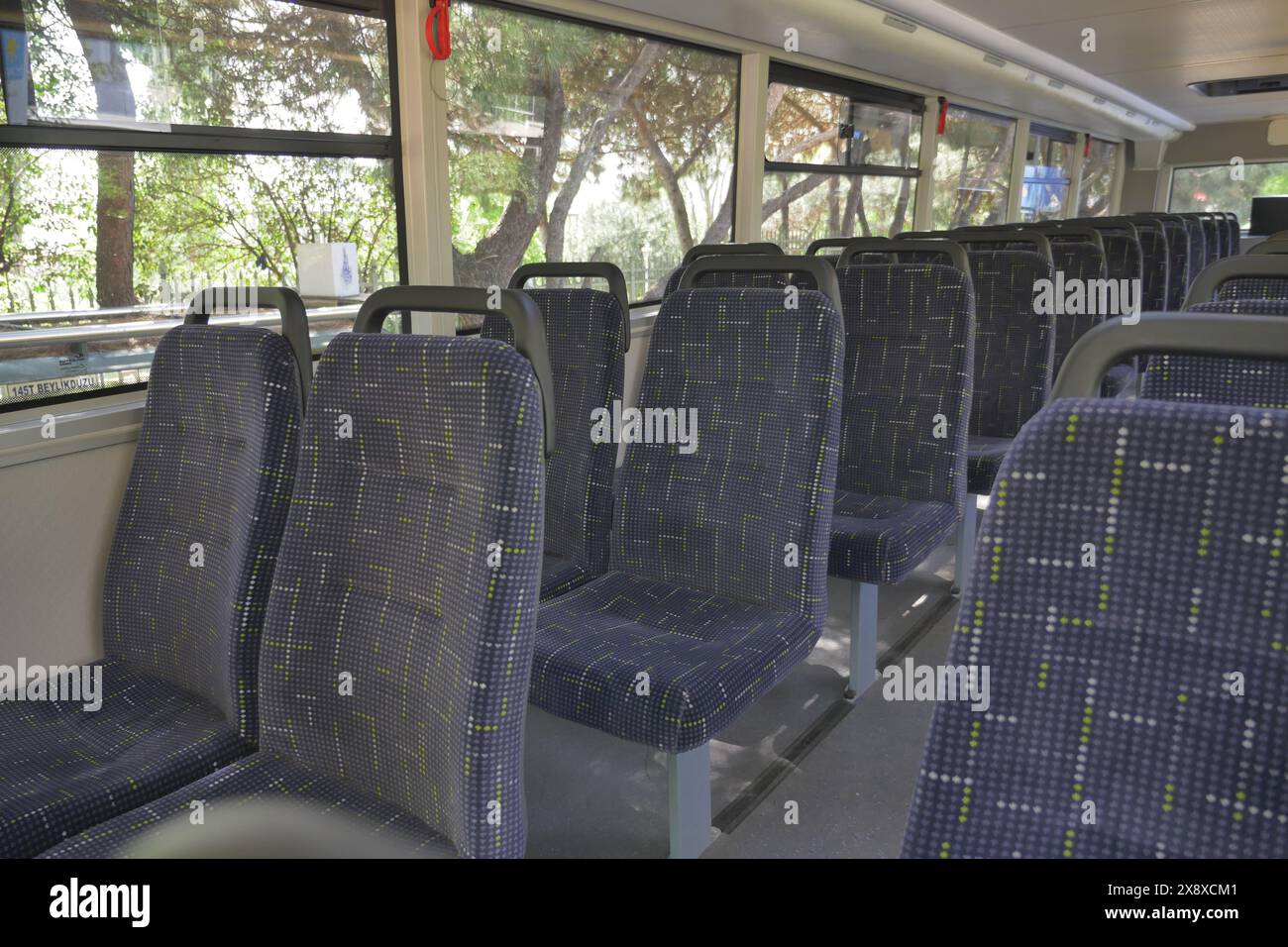 Blue seats inside of empty city bus Stock Photo - Alamy