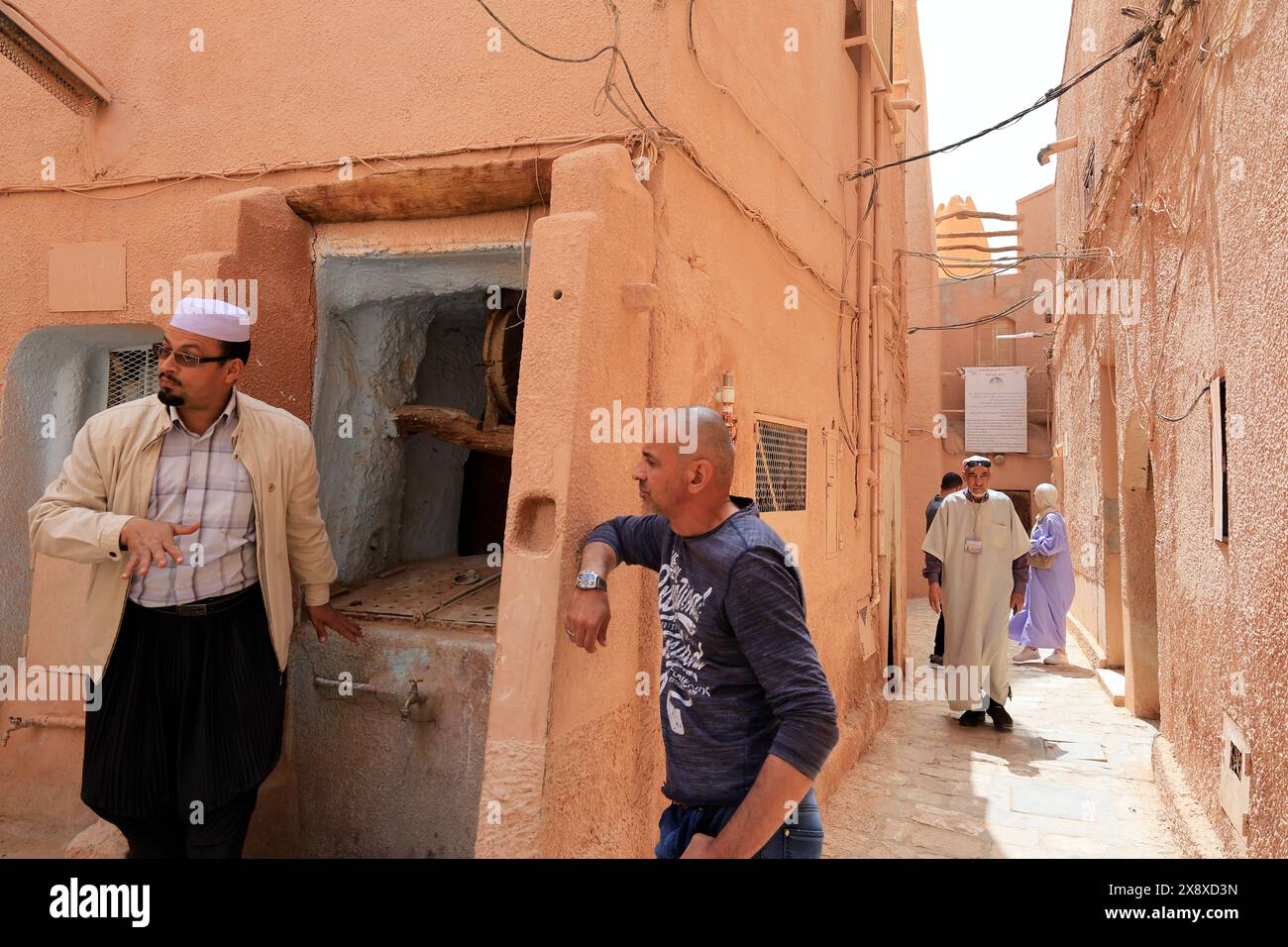 Visitors with tour guide visiting an ancient well inside Ksar Ghardaia ...