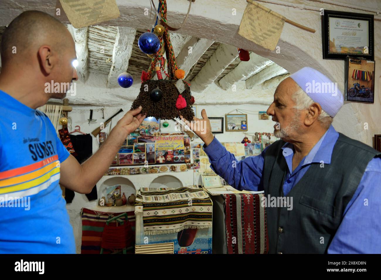 A visitor and guide looking at a traditional water container inside of ...
