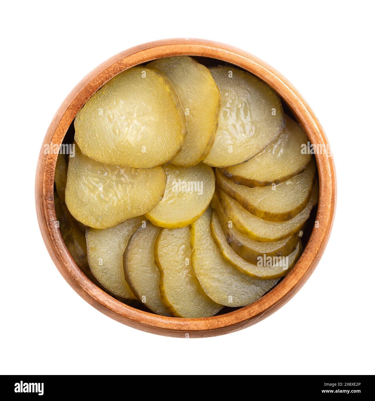 Burger gherkin slices, in a wooden bowl. Pickled cucumbers, cut in ...