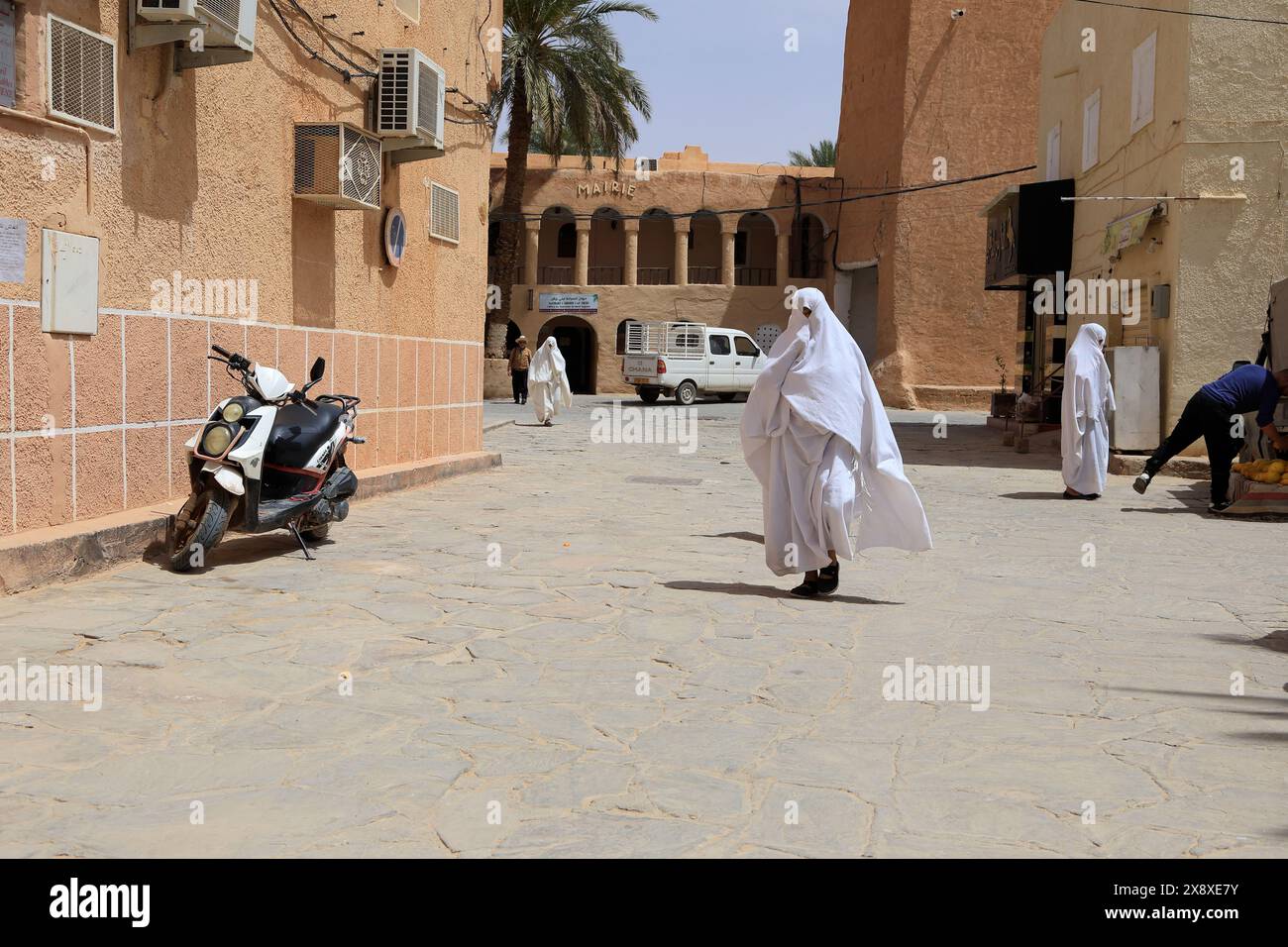 Veiled Mozabite women in white haik in market square of Ksar Beni ...