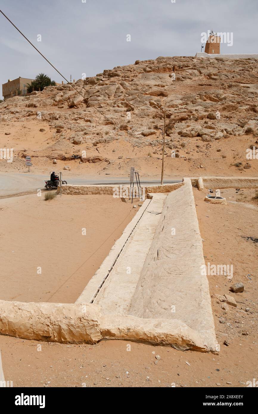A man looking at the well of underground water reservoir of the ...