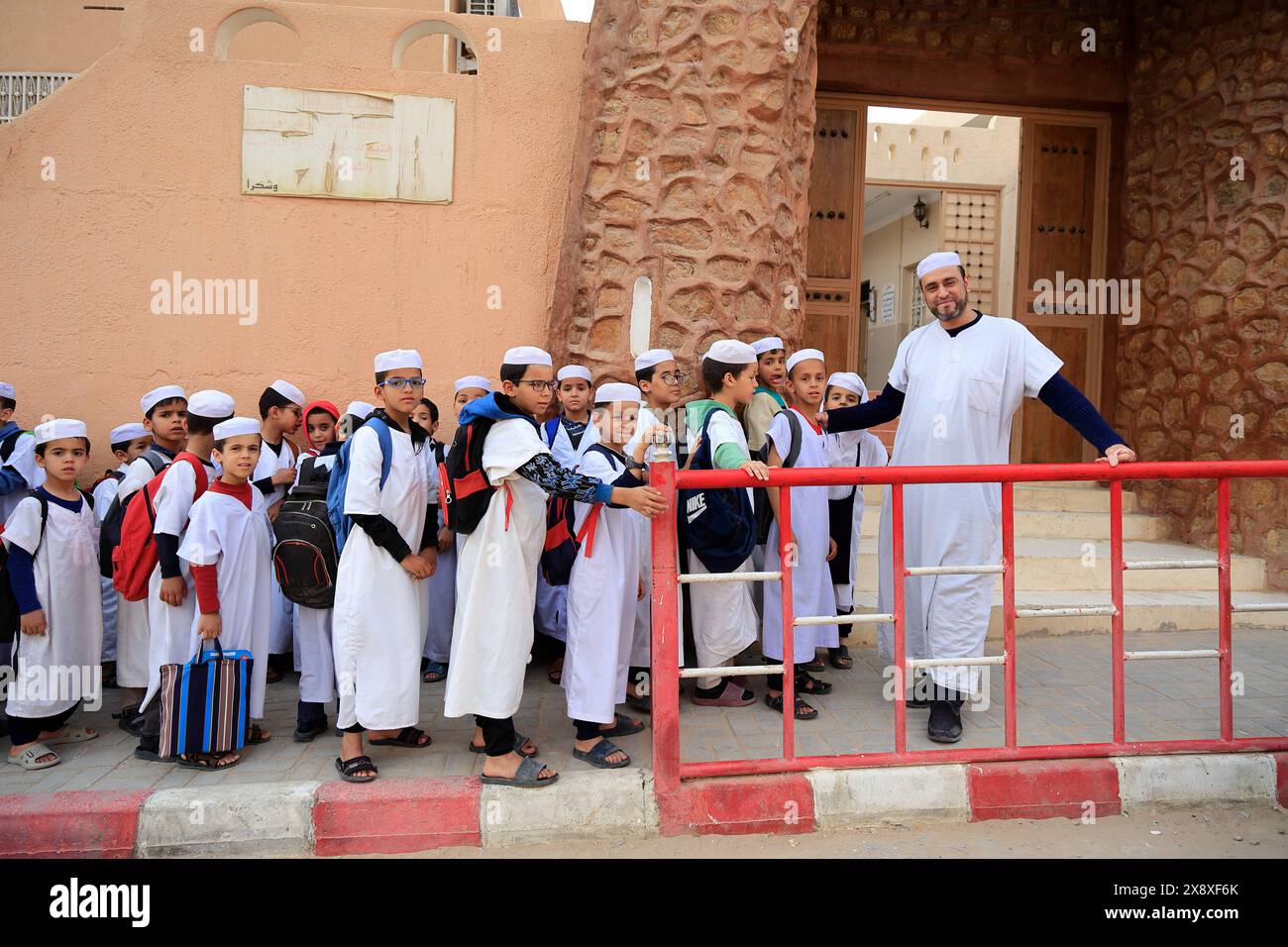 Students waiting outside of a Quran school before class start in ...