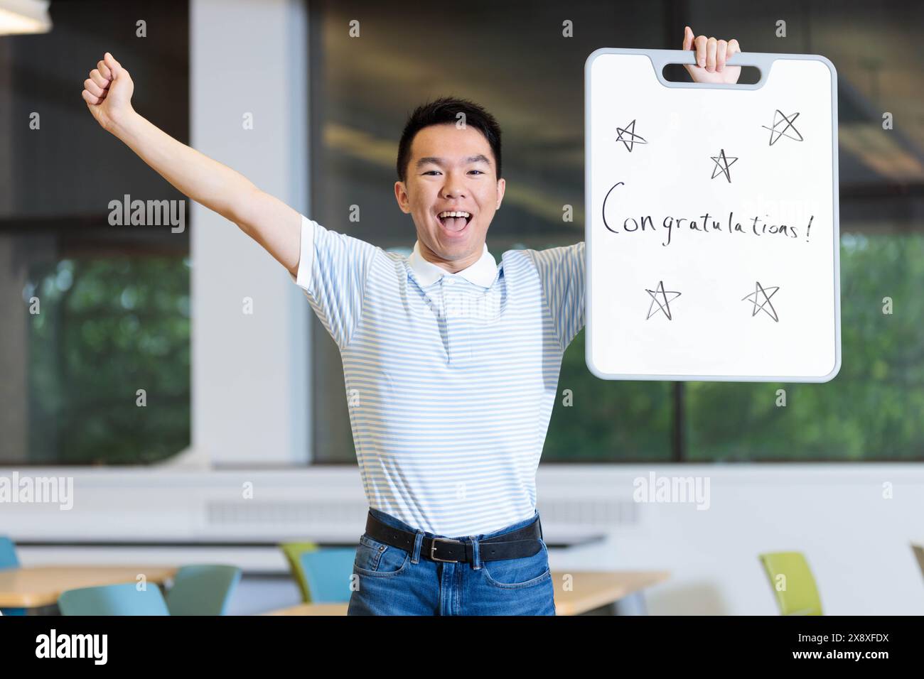 A young teenage male student is holding a sign saying congratulations ...