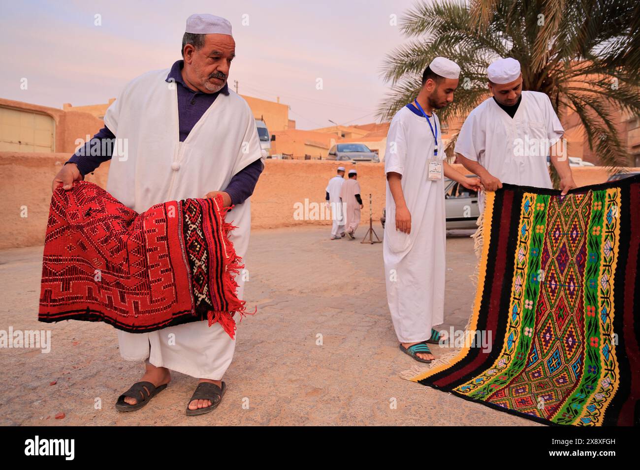 Mozabite men showing carpets and other goods for auction in a ...