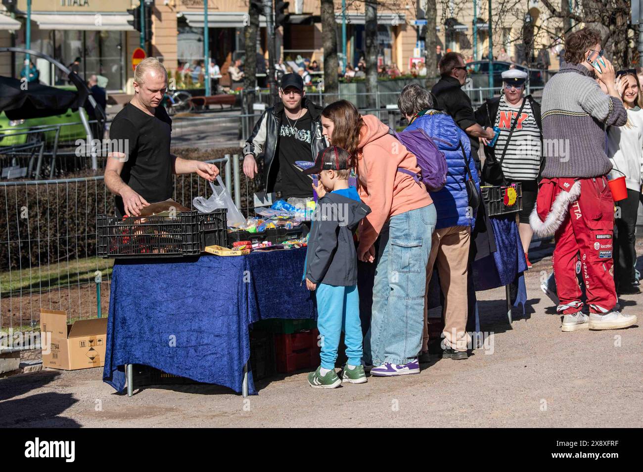 Customers selecting novelty items from street vendor's table on May Day ...