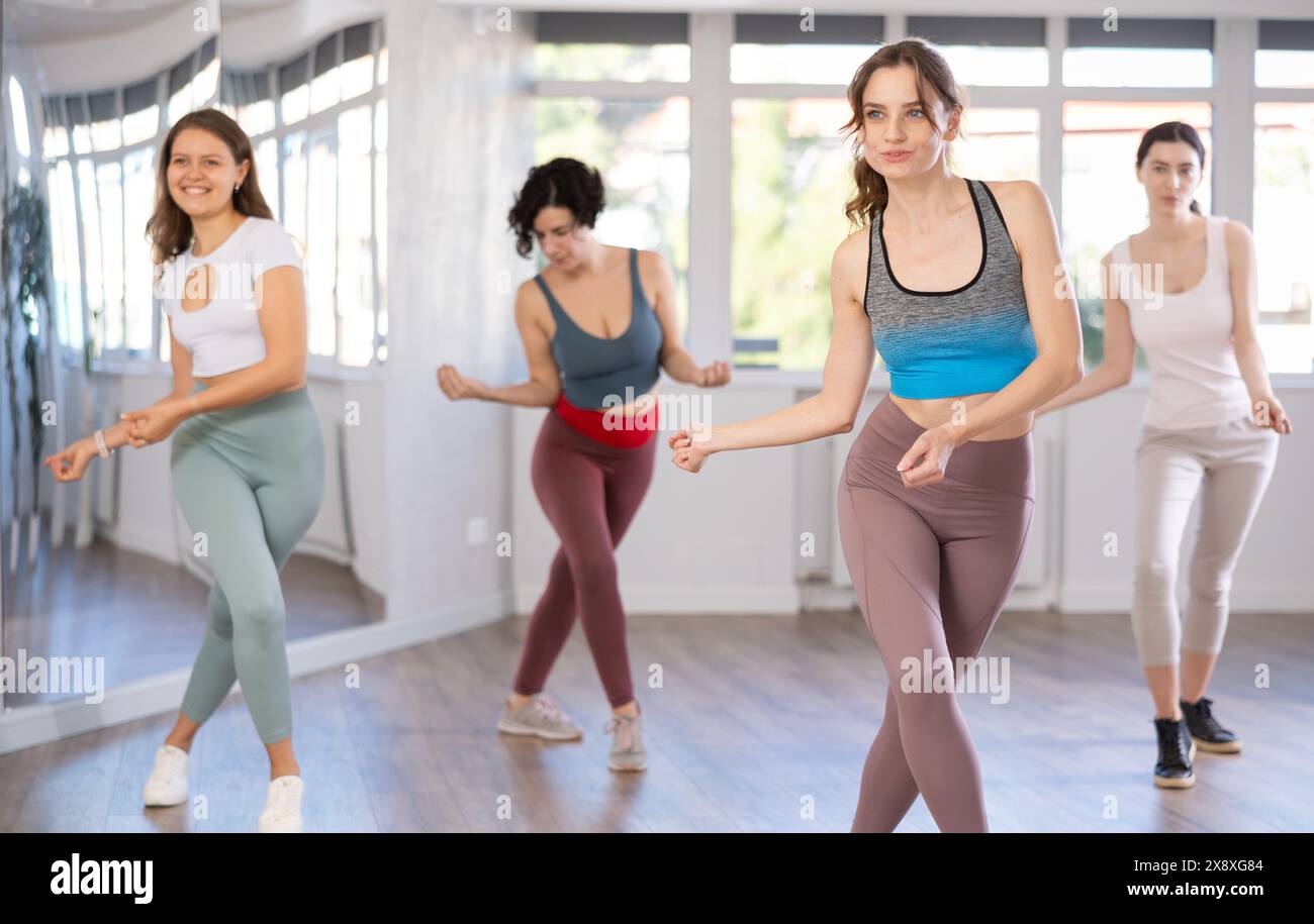 Happy women dancing synchronous group choreography in dance hall Stock ...