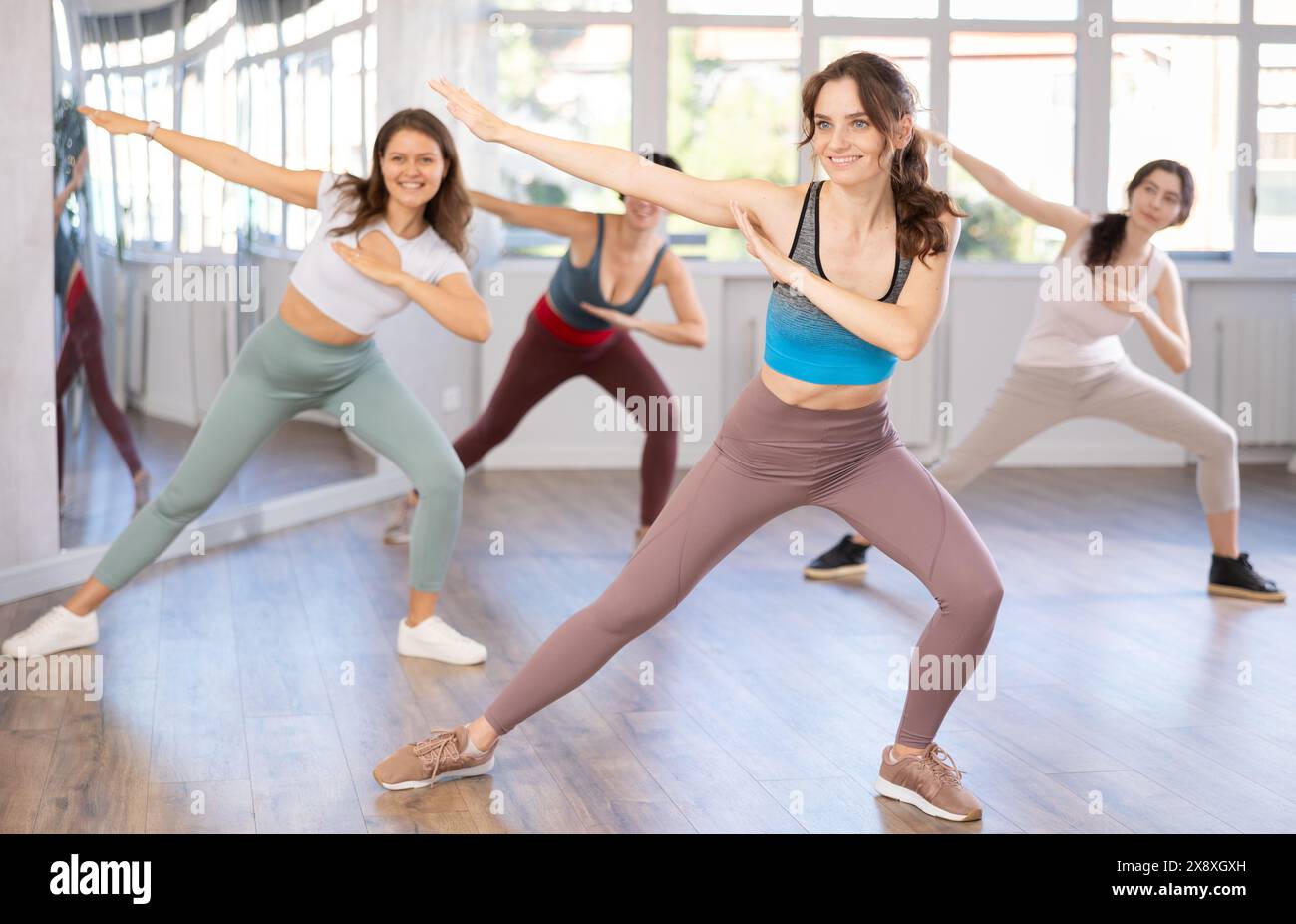 Young female teacher conducts modern hip hop dance lessons for group of ...
