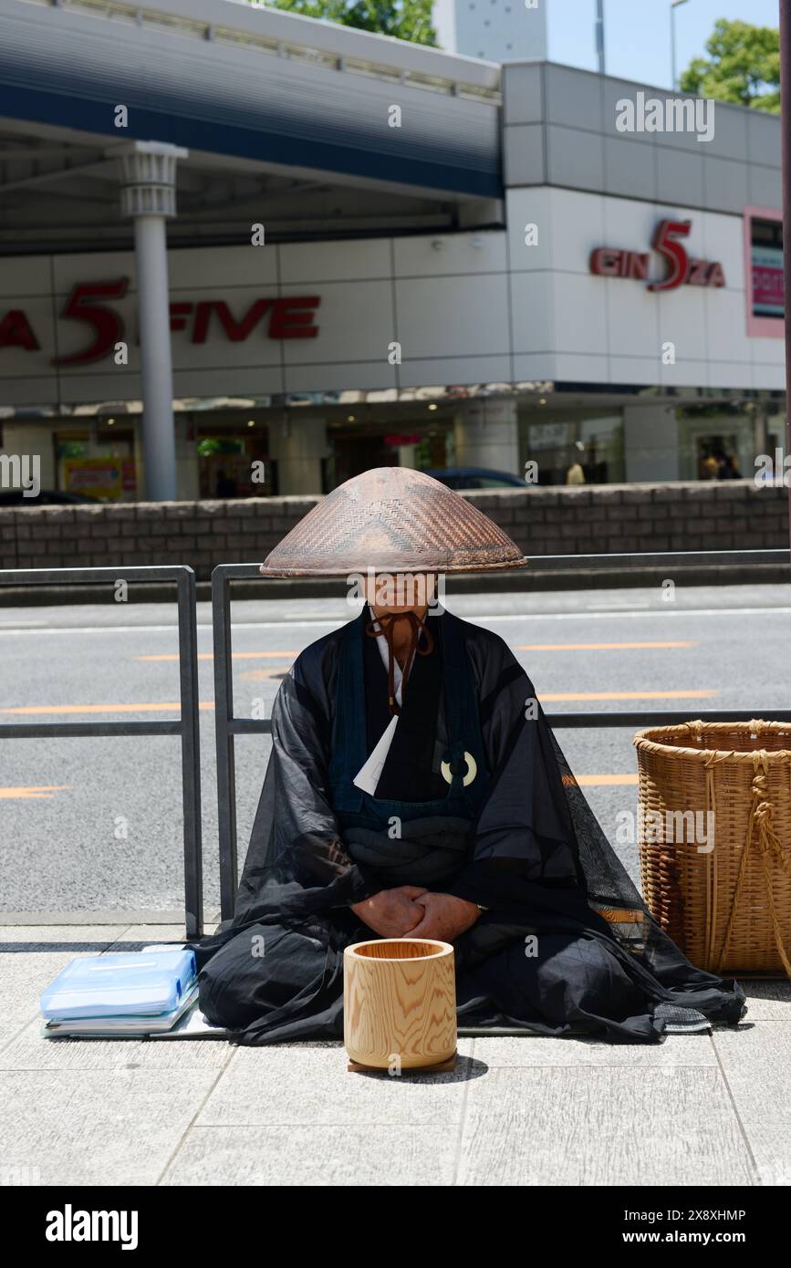 A Japanese Zen monk collecting alms on a main commercial street in ...