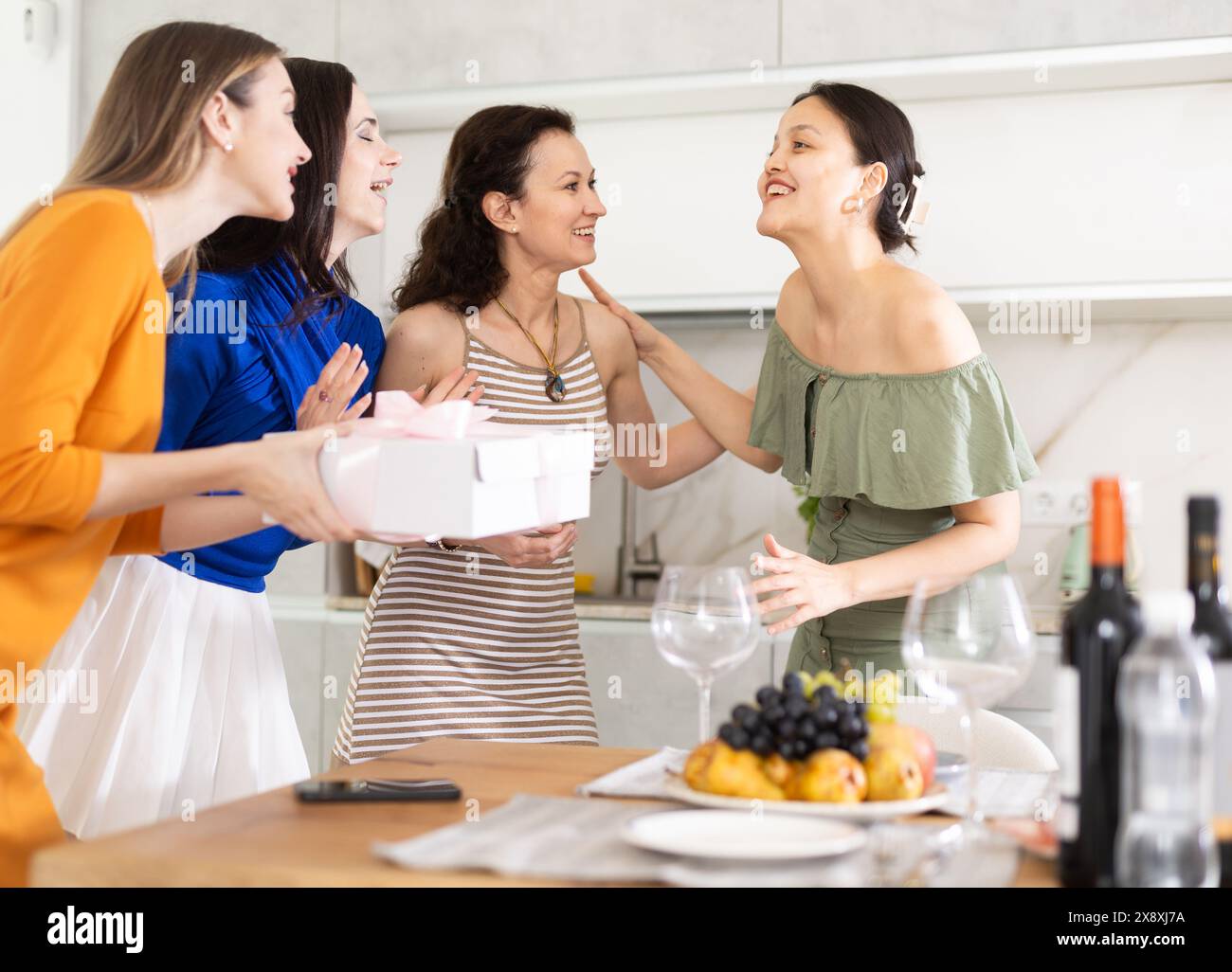 Happy women greeting each other before starting house party Stock Photo ...
