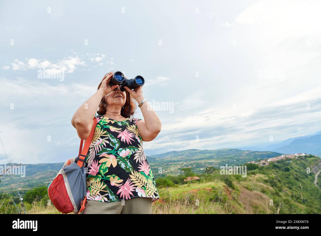 Unknown woman observing from a viewpoint, trough binoculars, Barichara ...