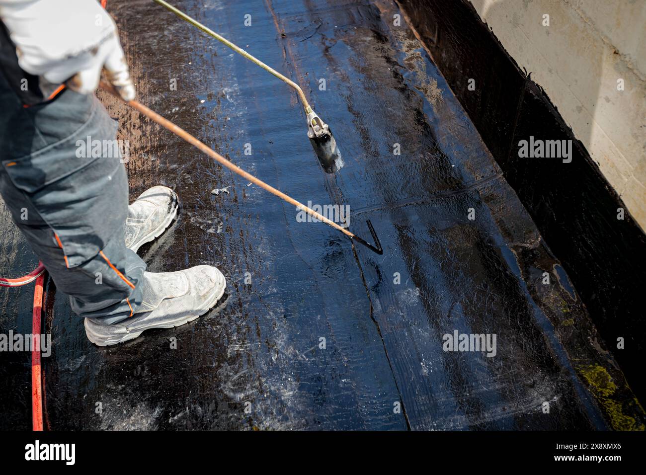 Worker is heating, melting bitumen waterproofing installation over ...