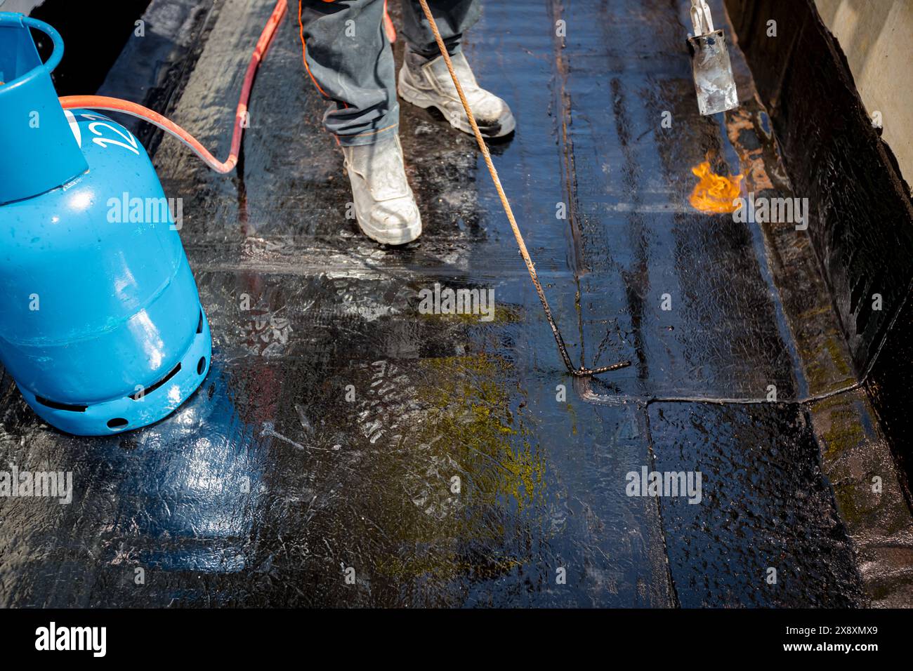 Worker is heating, melting bitumen waterproofing installation over ...
