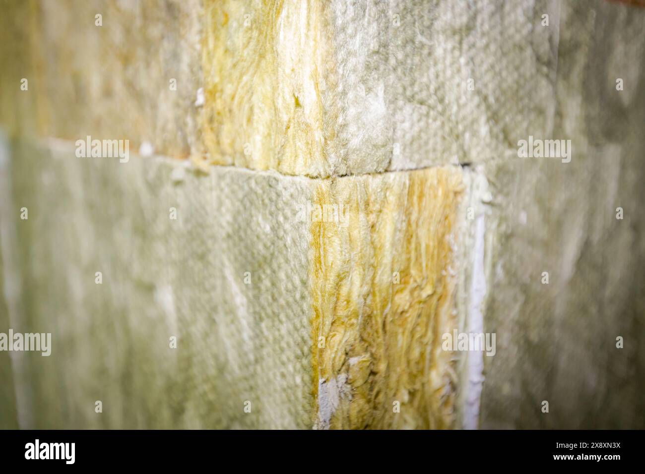Corner of indoor wall with unfinished thermal insulation, layer of rock ...