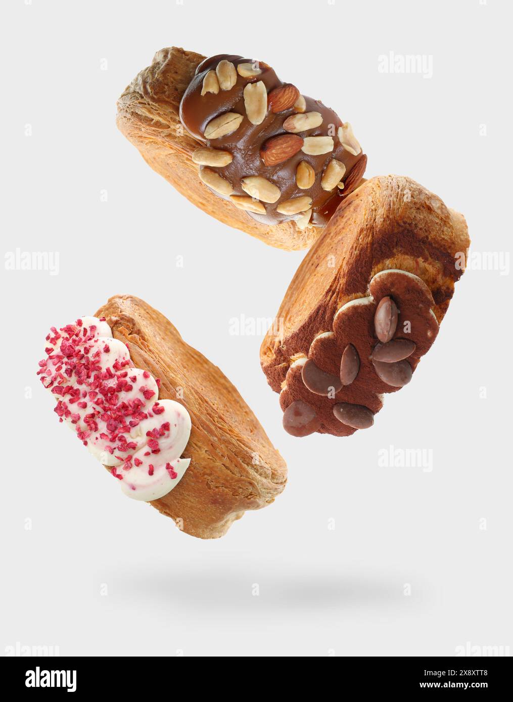 Delicious round croissants in air on light background. Puff pastry ...