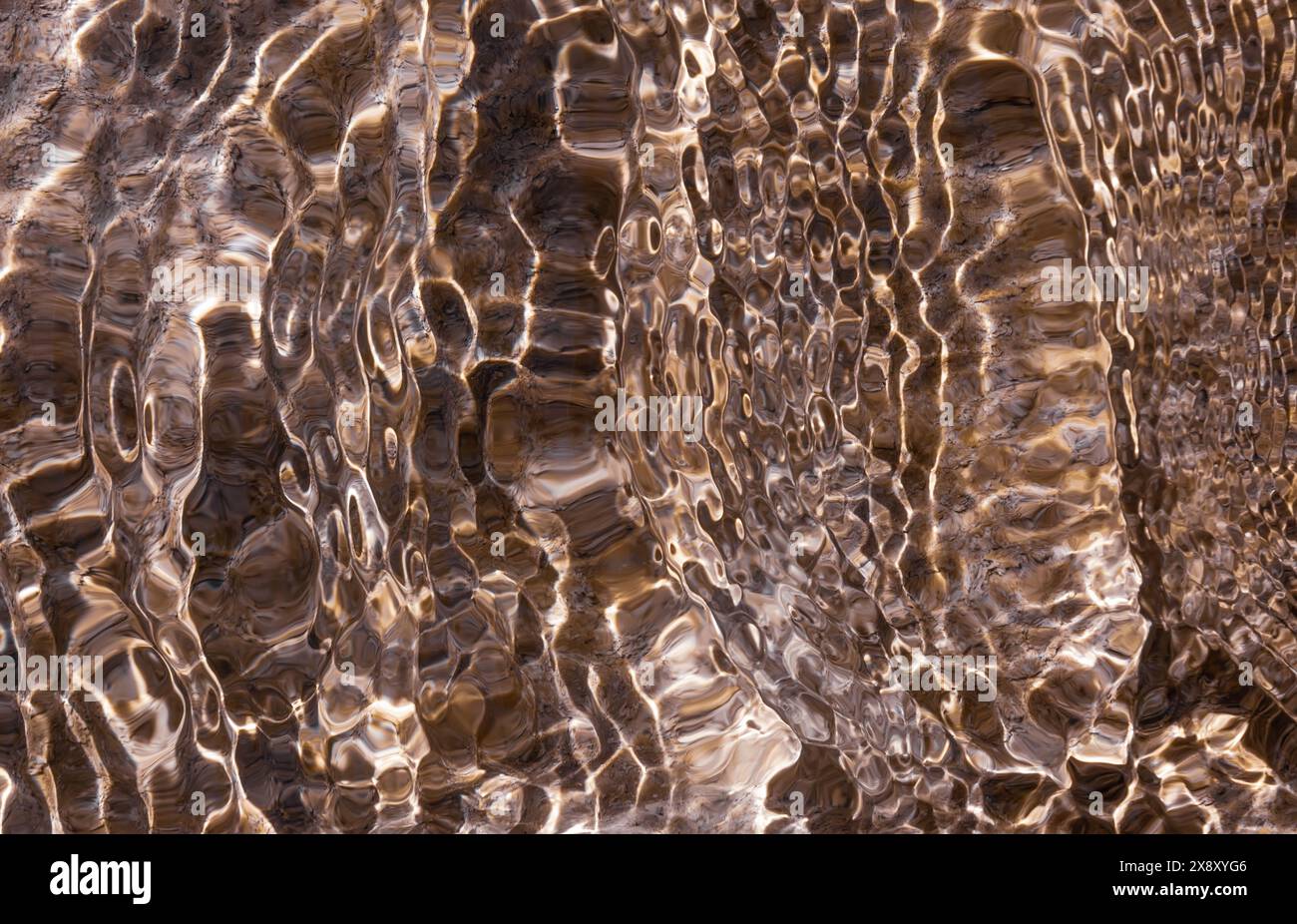 The source of this small stream of clear water spills over a bed of ...