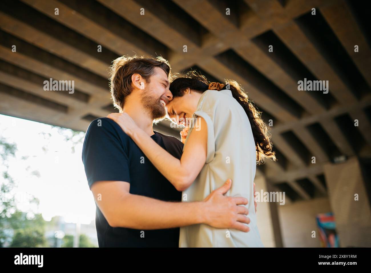 Couple sharing a joyful and tender embrace, smiling and leaning into ...