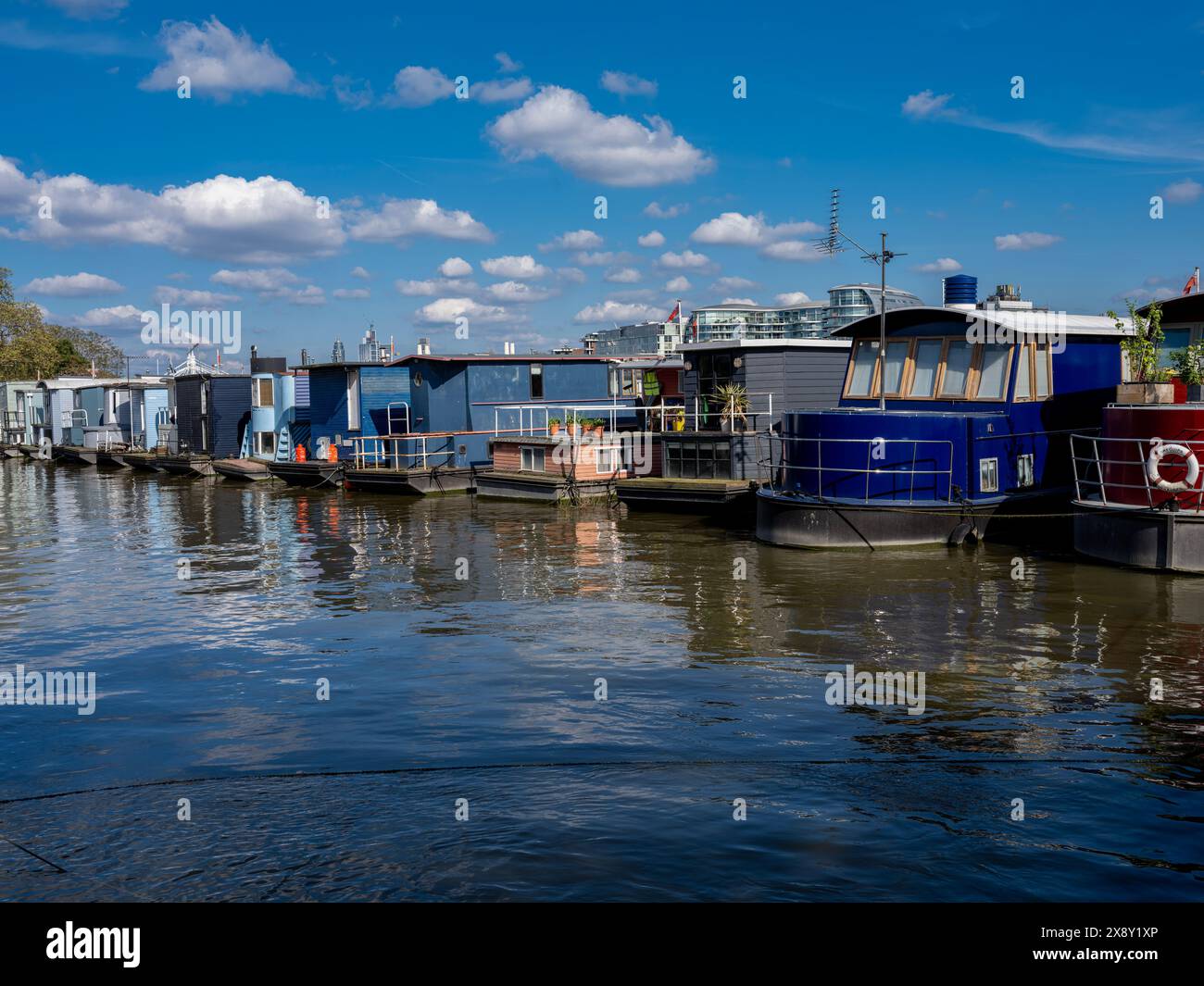 Barges and houseboats moored on Chelsea wharf, on the River Thames ...