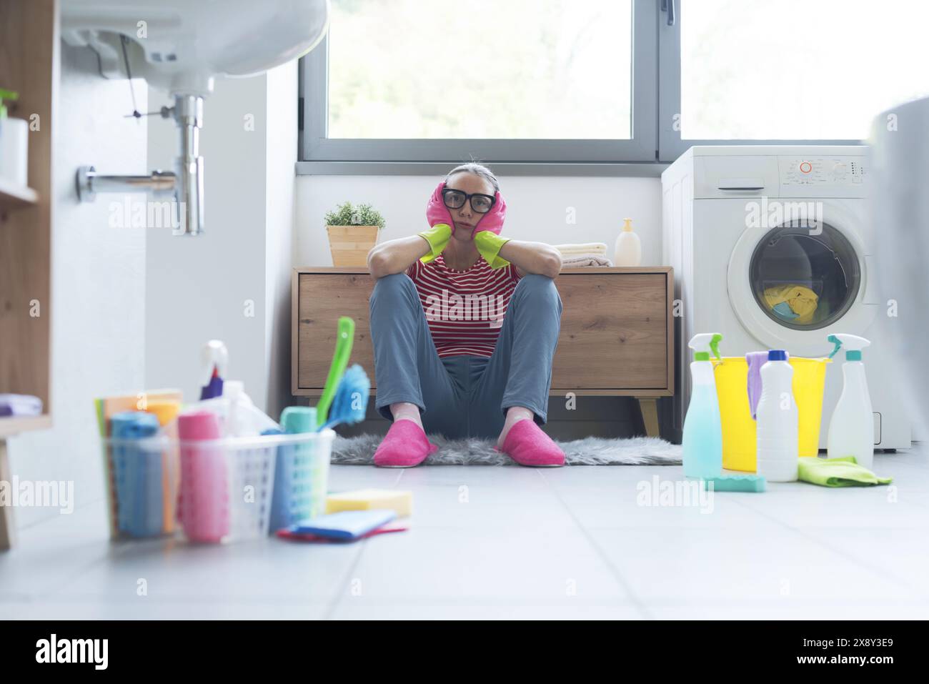Frustrated bored woman sitting on the floor in the bathroom, she is ...