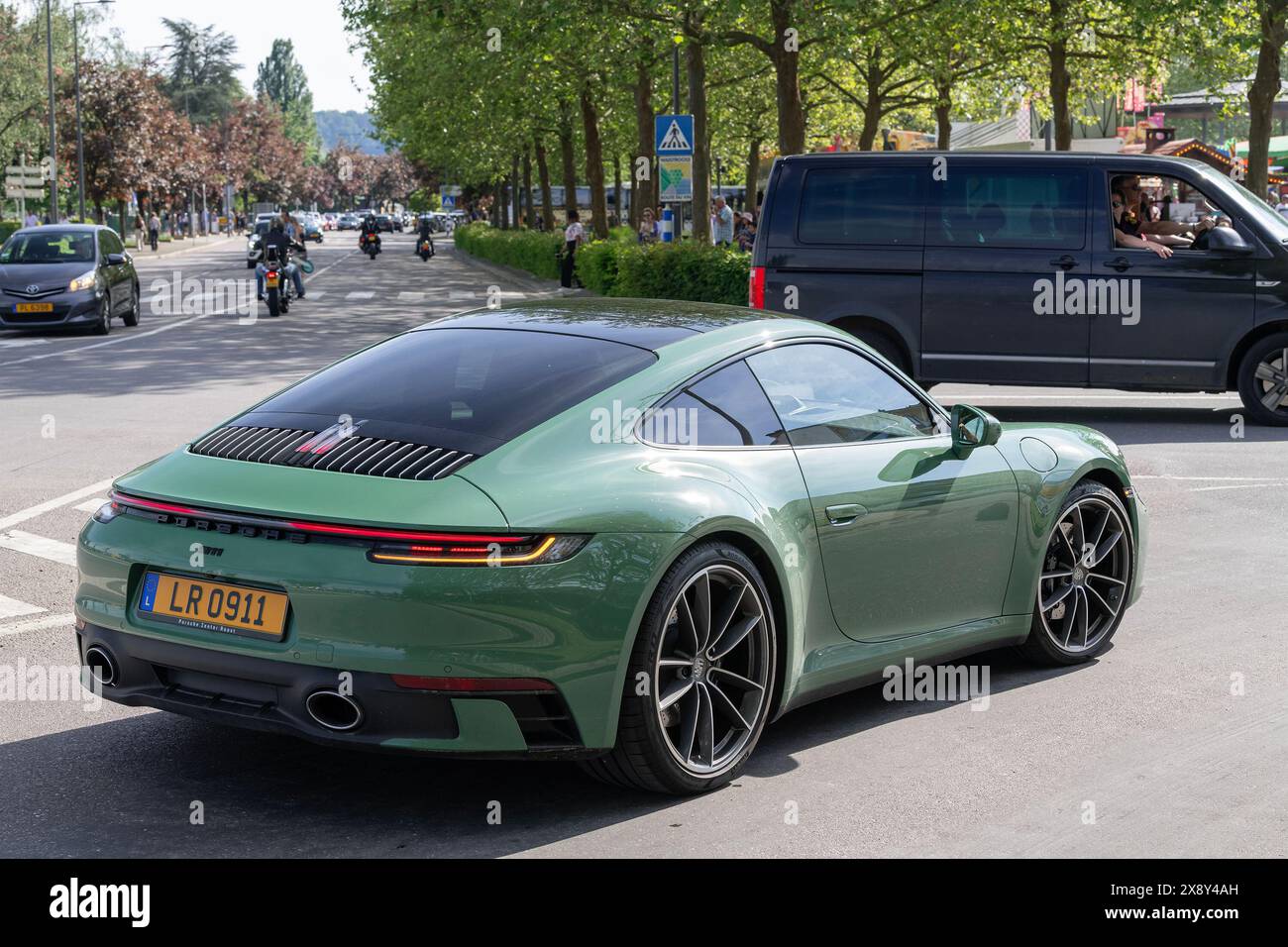 Remich, Luxembourg - View on a green Porsche 992 Carrera driving on a ...