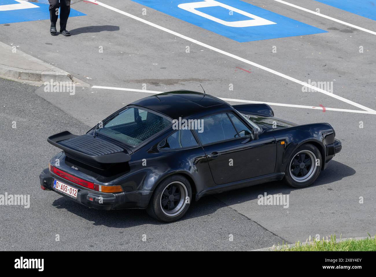 Berchem, Luxembourg - View on a black Porsche 930 Turbo driving on a ...