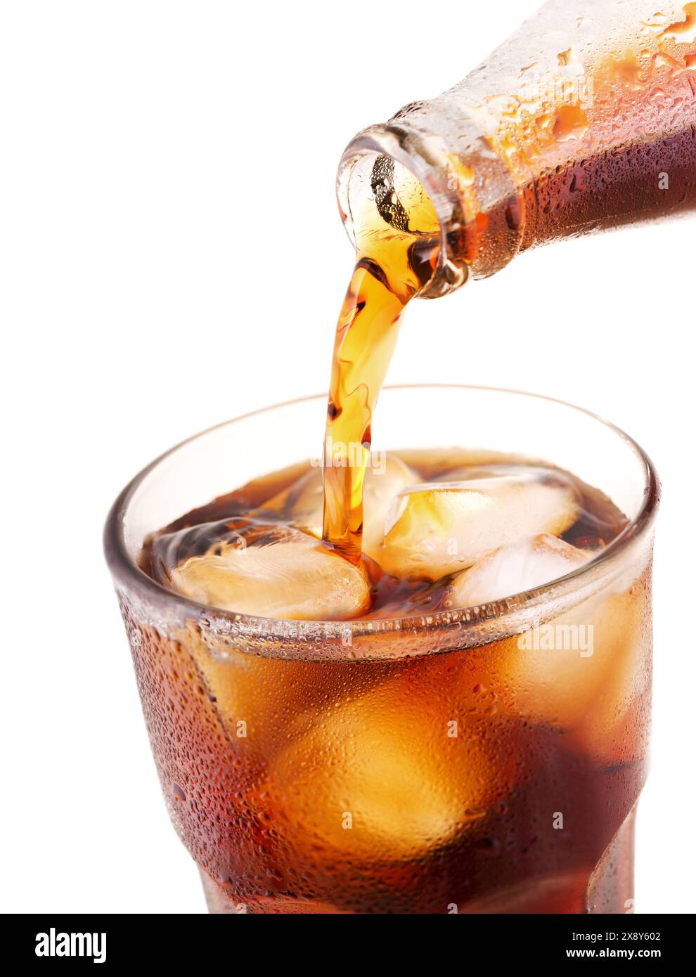 pouring cola into glass with ice from bottle isolated on white ...