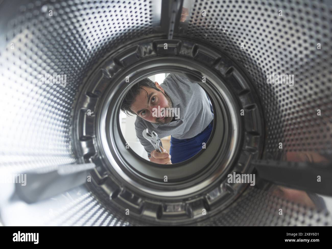 Repairman fixing a washing machine, view from the inside of the ...
