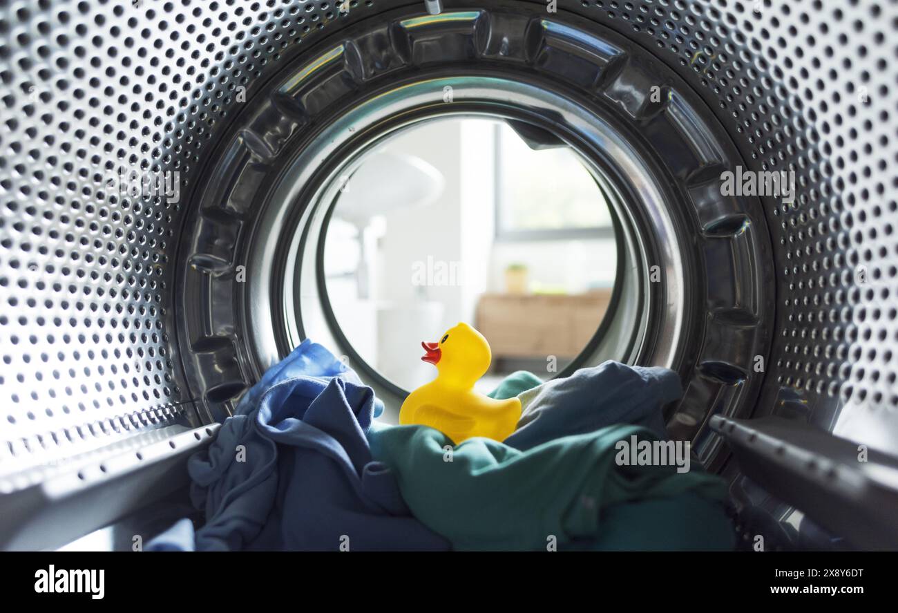 Clothes and rubber duck inside the washing machine, laundry and hygiene ...