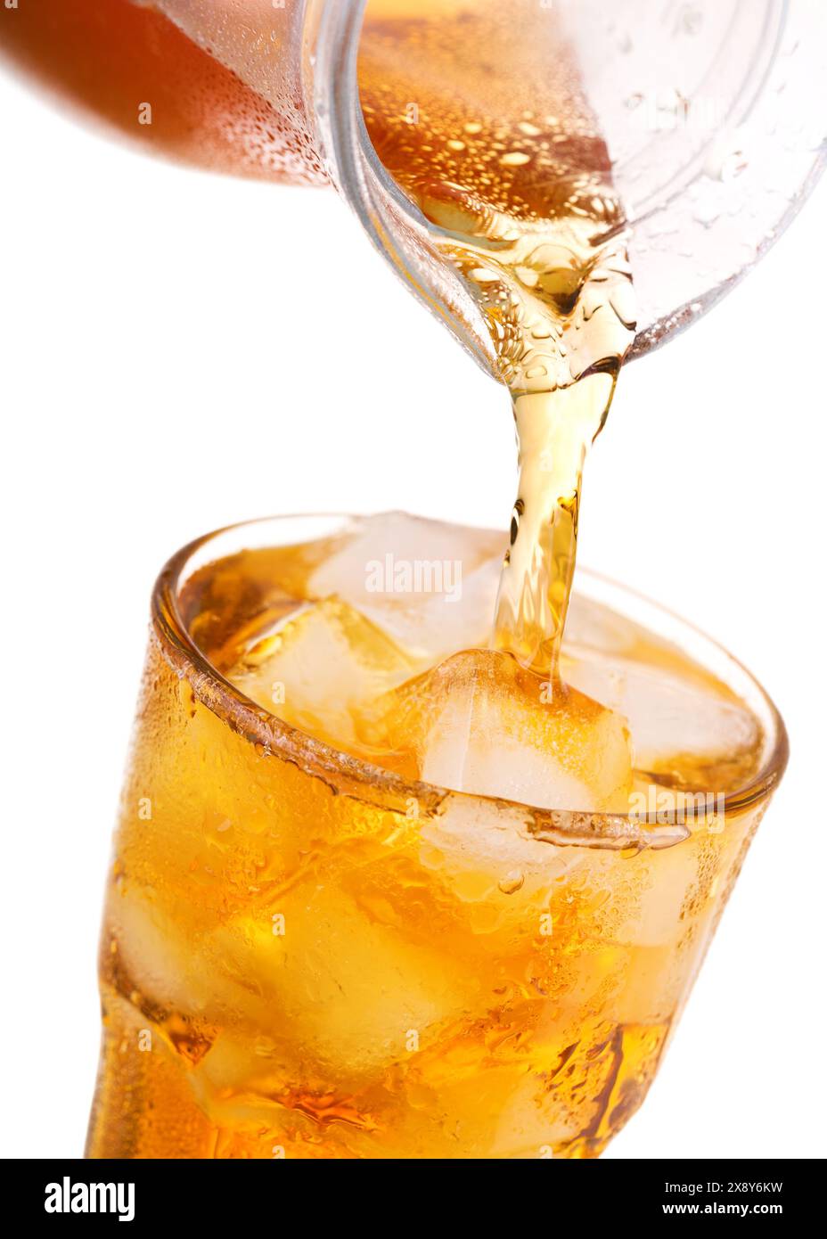 pouring iced tea into glass with ice from jar isolated on white ...