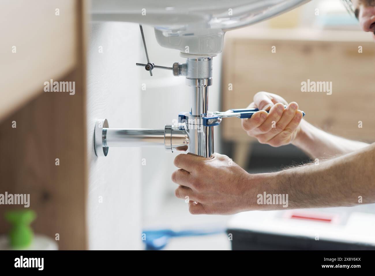 Professional plumber fixing a bathroom sink drain using water pump ...