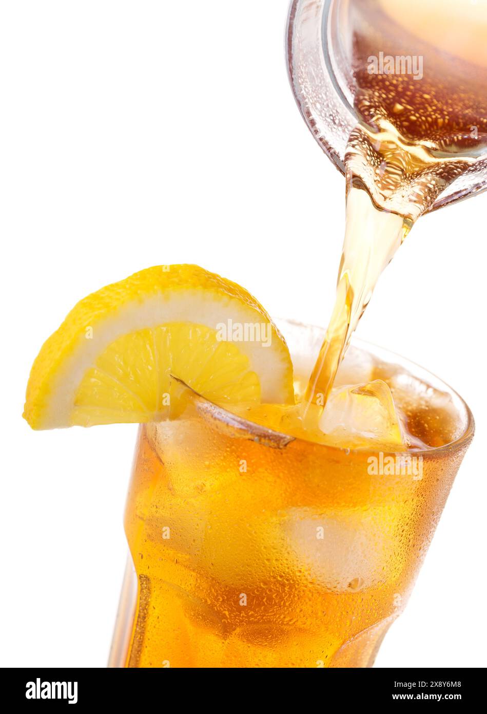 pouring iced tea into glass with ice and lemon from jar isolated on ...