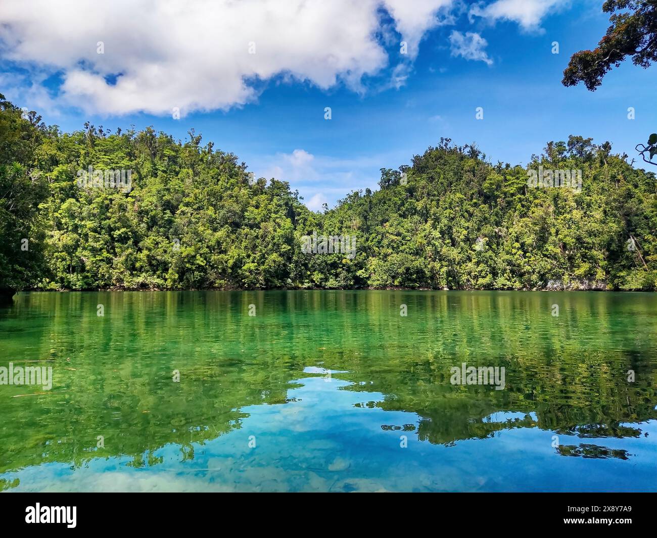 A picturesque scene of hills towering over a serene, azure lagoon Stock ...
