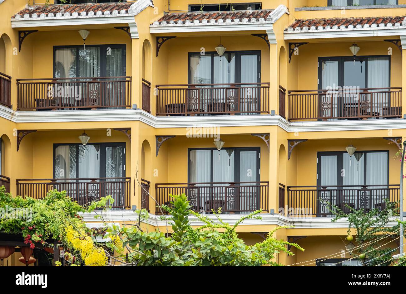 Beautiful building in antique style among green trees. The balconies ...