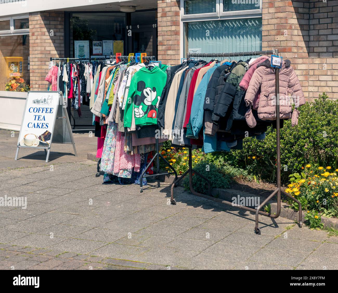 Charity clothes wrack and refreshment sign standing outside the doorway ...