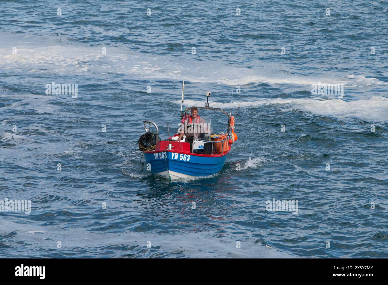 Small open boat with single fisherman setting and pick up crab pots ...
