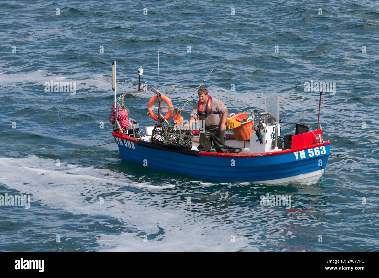 Small open boat with single fisherman setting and pick up crab pots ...